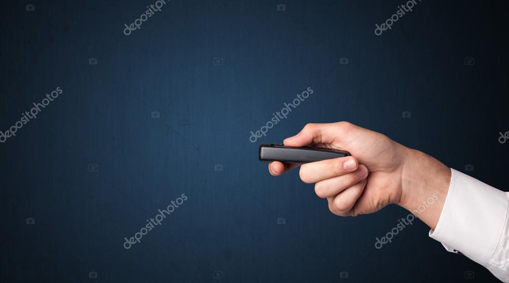 Hand with remote control Stock Photo by ©ra2studio 107853642