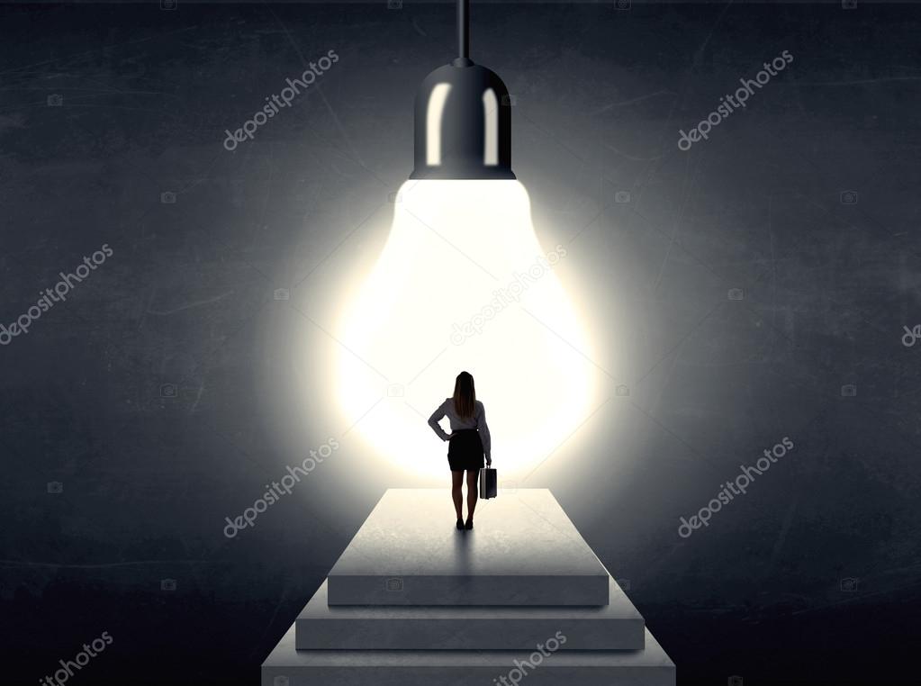 Woman standing on a step in front of a huge light bulb — Stock Photo ...