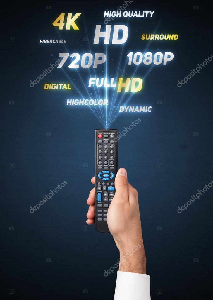 Hand with remote control and multimedia properties — Stock Photo ...