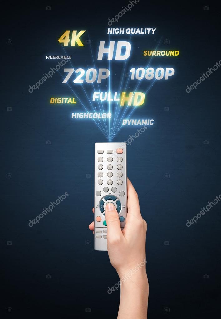 Hand with remote control and multimedia properties — Stock Photo ...