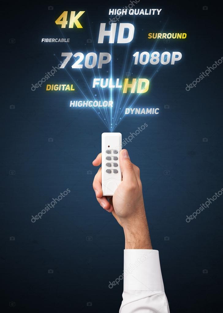 Hand with remote control and multimedia properties — Stock Photo ...