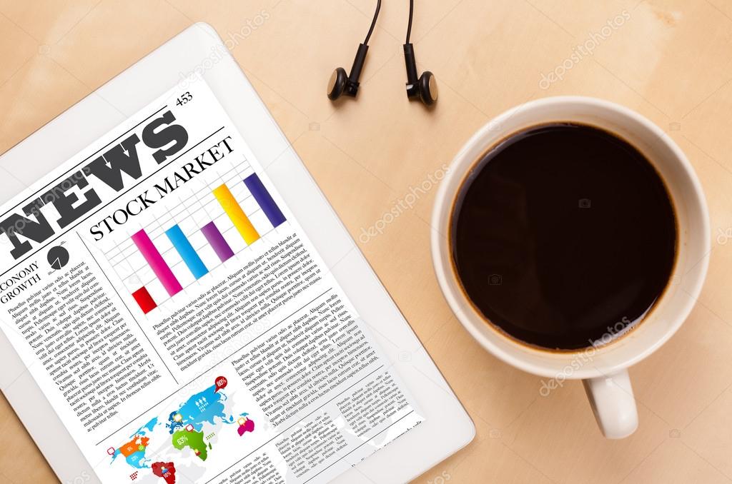 Tablet pc shows news on screen with a cup of coffee on a desk Stock ...