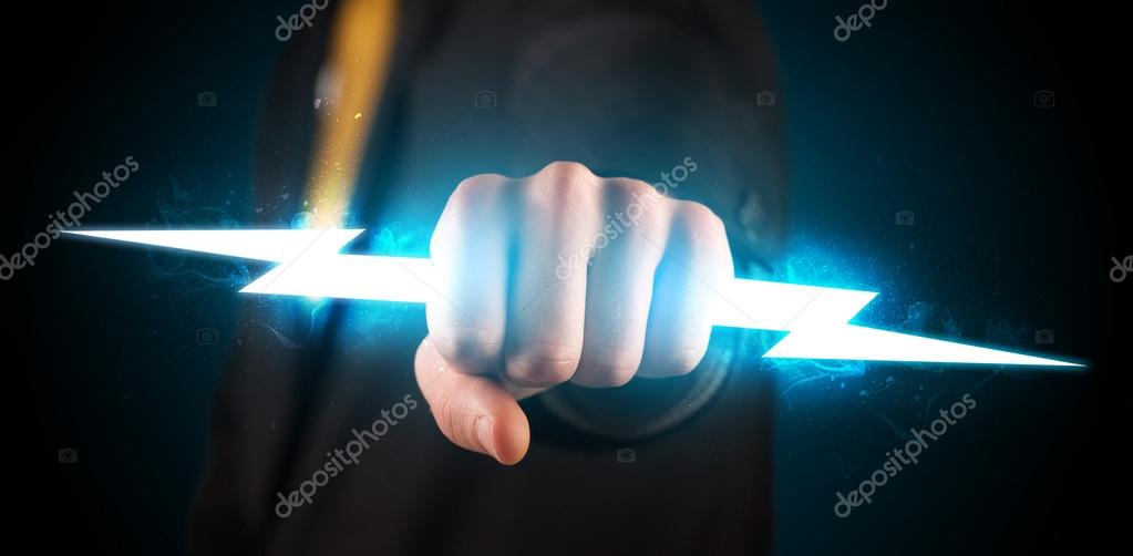 Business man holding glowing lightning bolt in his hands Stock Photo by ...