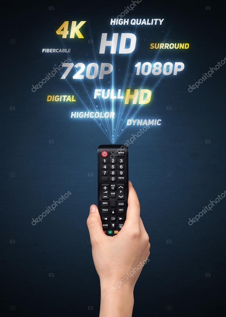 Hand with remote control and multimedia properties — Stock Photo ...