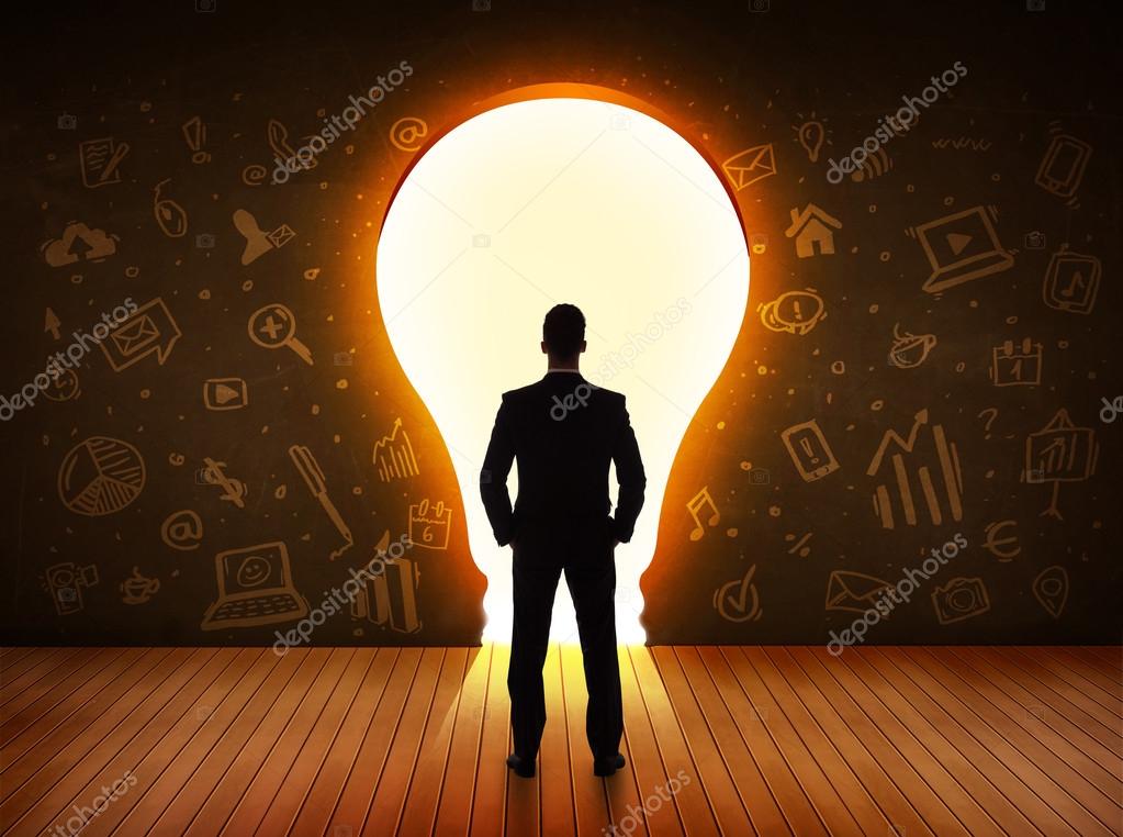 Business man looking at bright light bulb in the wall — Stock Photo ...