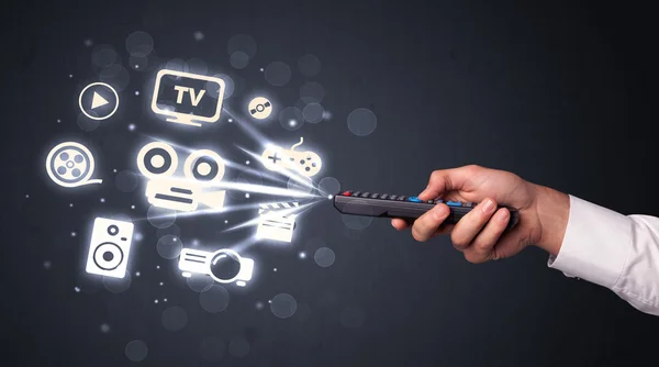 Hand with remote control and social media icons — Stock Photo ...