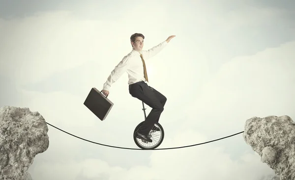 Brave business man riding an mono cycle between cliffs — Stock Photo ...