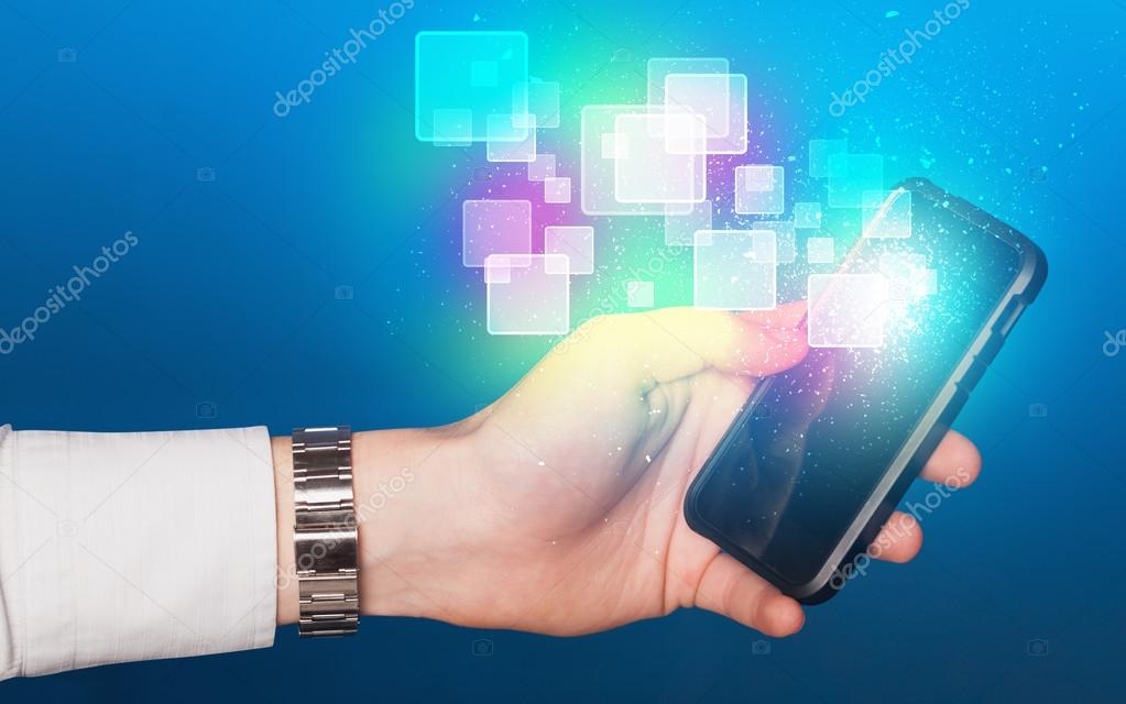 Hand holding smart phone with abstract glowing squares — Stock Photo ...