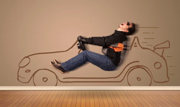 Happy man driving an hand drawn car on the wall - Stock Image - Everypixel