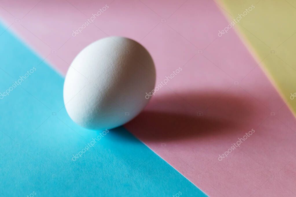 Concepto de Pascua. Huevo blanco sobre fondo multicolor en colores ...