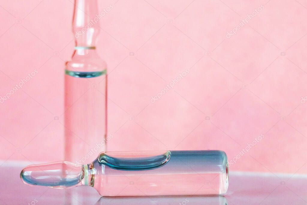 Ampollas para productos médicos y cosméticos sobre fondo rosa. Sustancia solución inyectable 2022