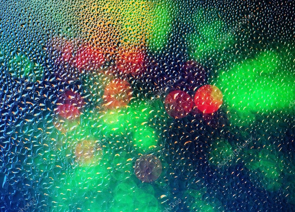 Drops of rain on glass with defocused lights. Abstract blurred b ...