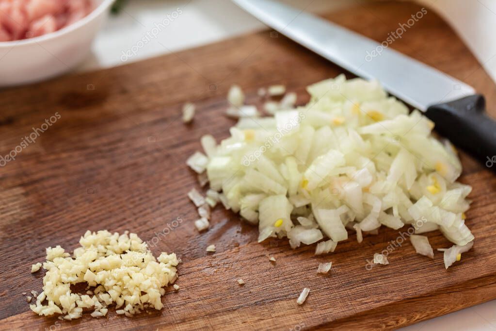 Cocinar rollos de col con carne de pollo en casa. Cortar cebollas y ajo ...