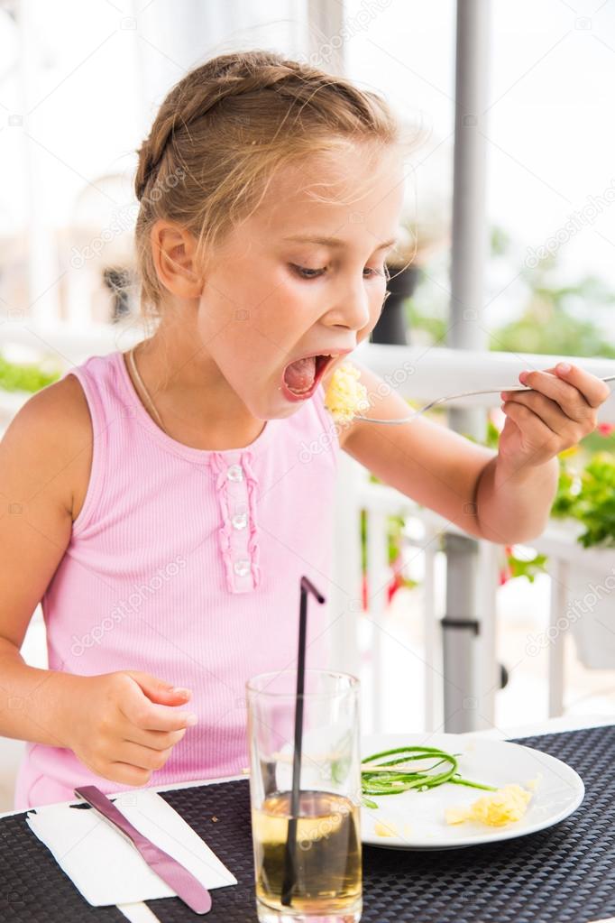 Cute girl eating lunch in cafe Stock Photo by ©Len44ik 52966629