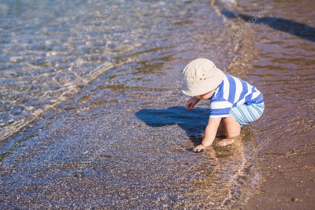 Cute little baby boy exploring the beach — Stock Photo © Len44ik #76288439