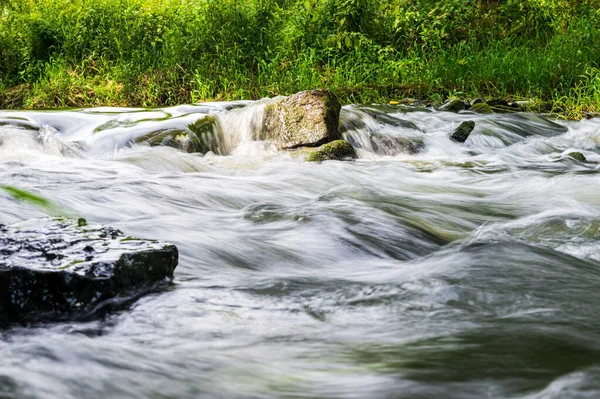 River flow over rocks in summer day. Waves of the river flow. Relaxing ...