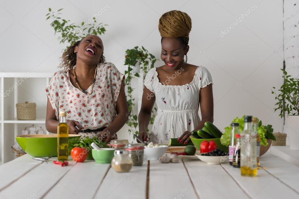 Two african women cooking salad — Stock Photo © HASLOO #65007901