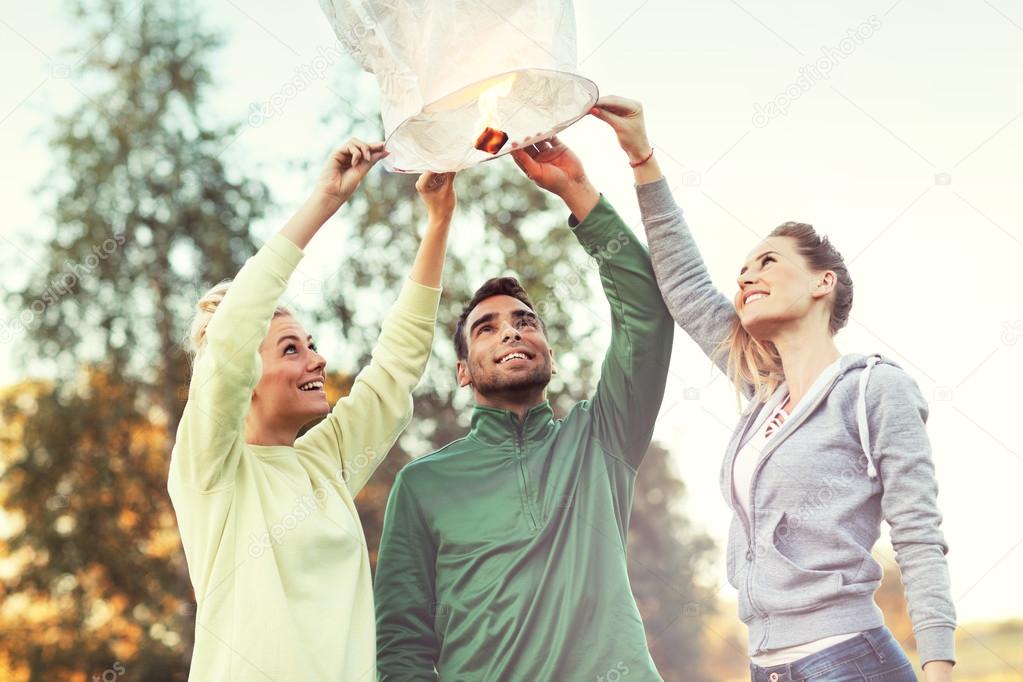 Group of friends floating chinese lantern Stock Photo by ©macniak 121181326