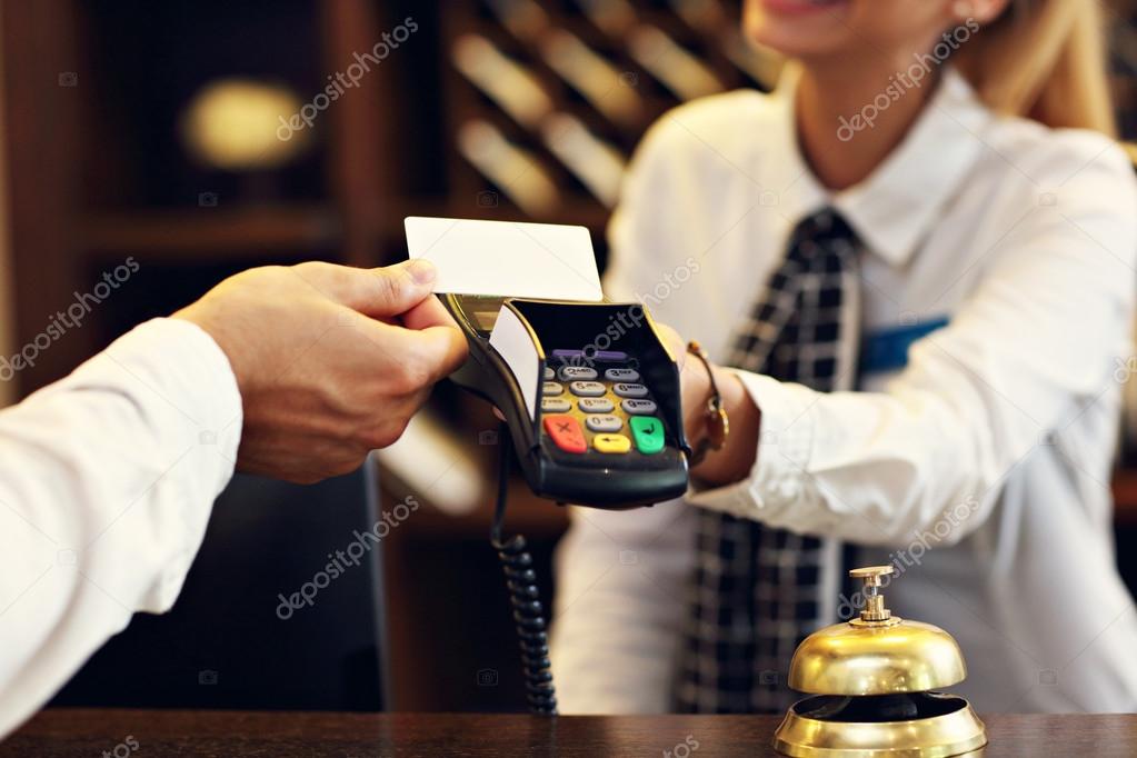 Man at counter paying for hotel — Stock Photo © macniak #125640664