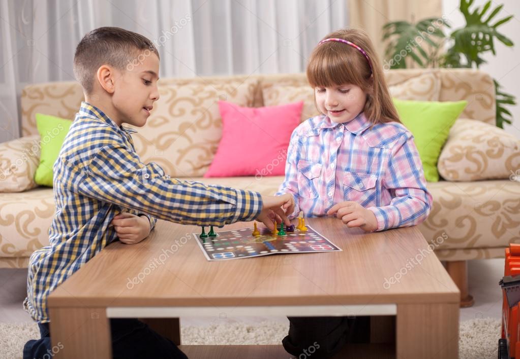 Children playing board game ludo at home on the table Stock Photo by ...