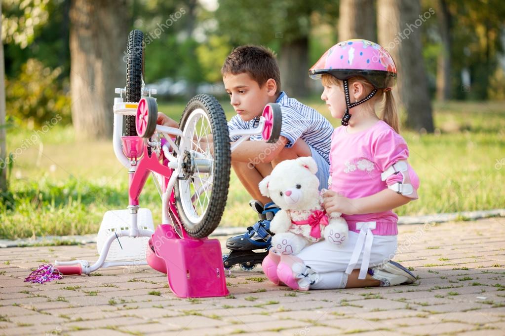 Little girl with a pink safety helmet learns how to fix bike Stock ...