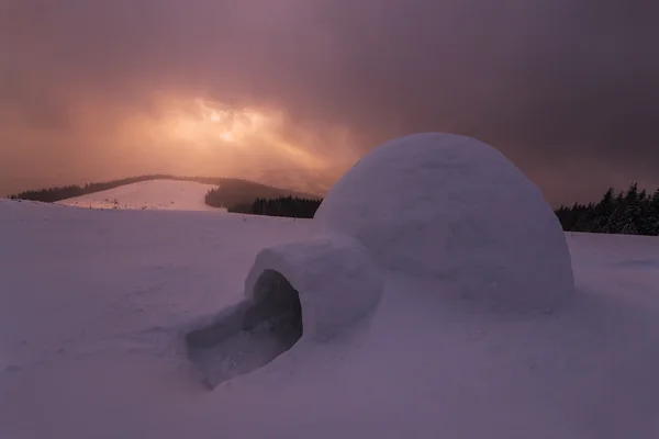 Real snow igloo house in the winter mountains glowing by evening ...