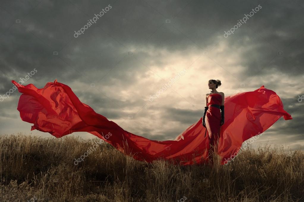 Woman in red dress waving on wind. Looking down. — Stock Photo ...