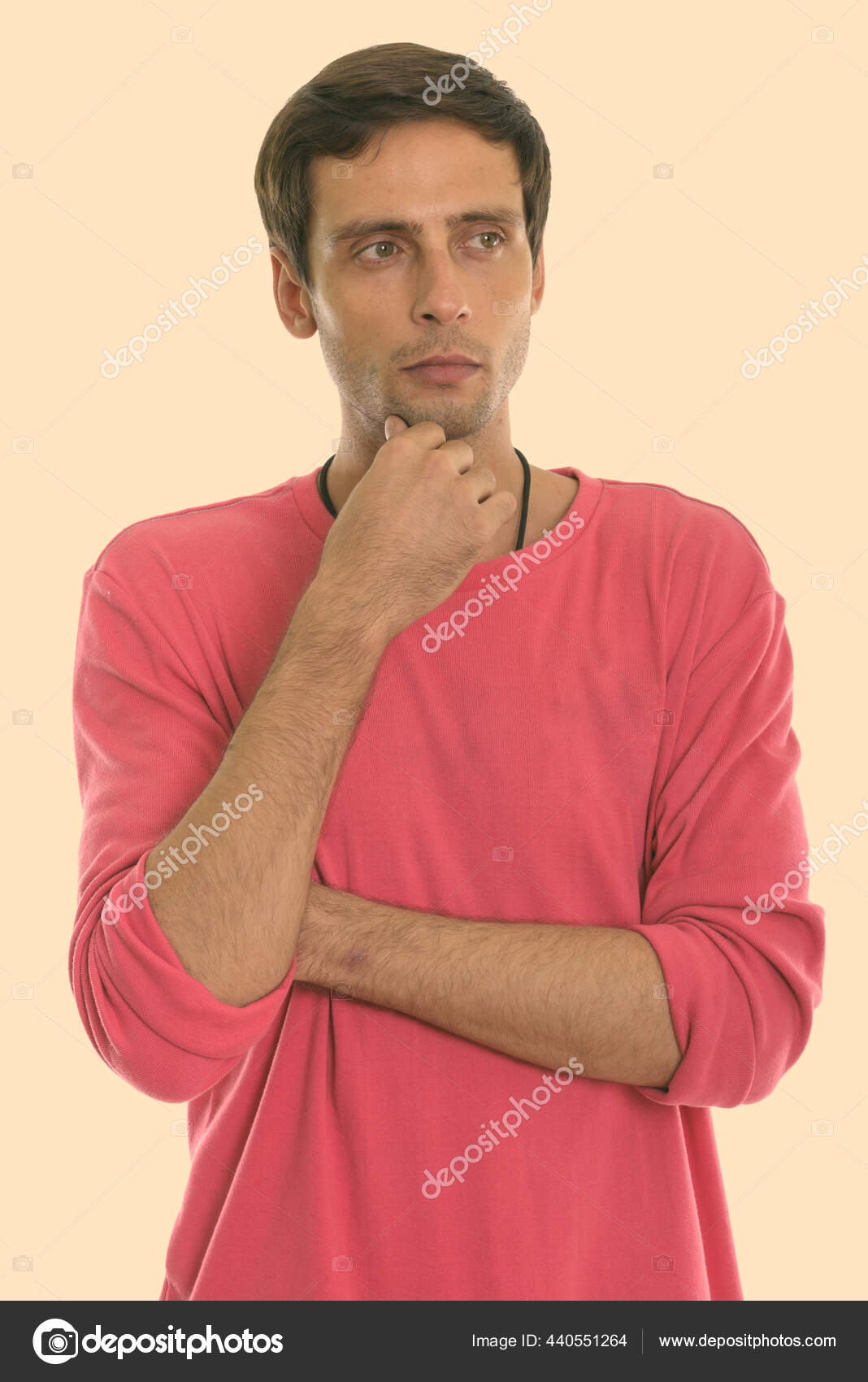 Studio shot of young handsome man thinking while looking at distance ...