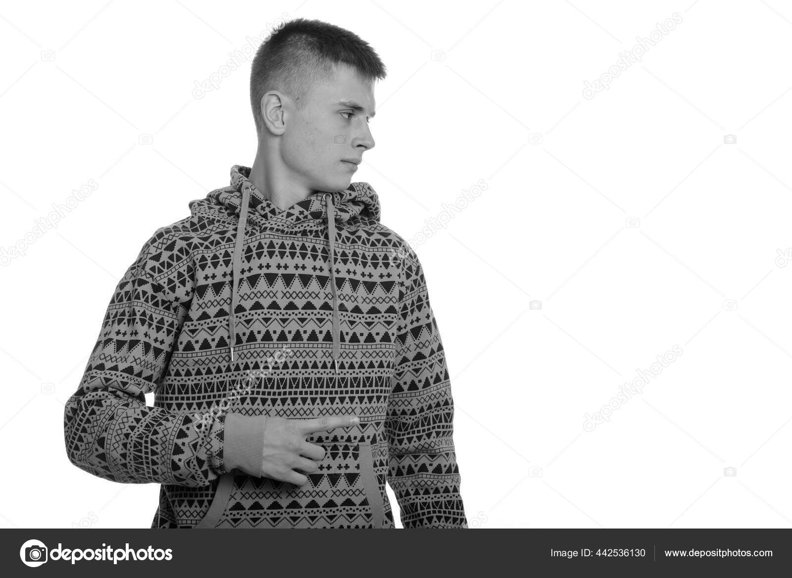 Profile view of young Caucasian man looking at side and pointing finger ...