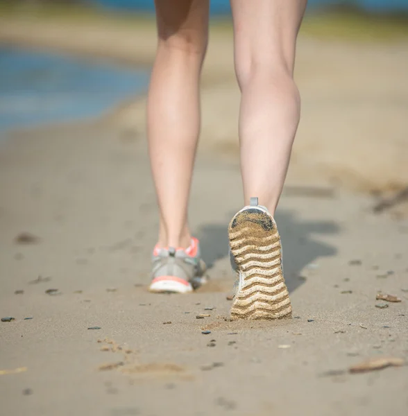 Sport footwear, sand footprints and legs close up. Runner feet d ...