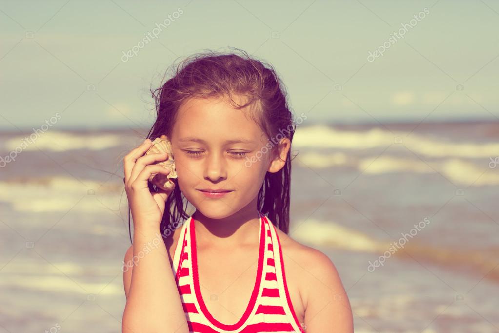 Little girl with shell Stock Photo by ©gurinaleksandr 52768405