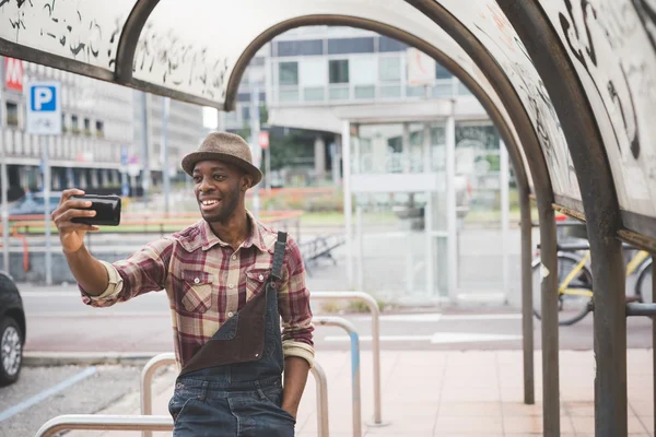 Afro black man holding a smartphone Stock Photo by ©peus 91048302