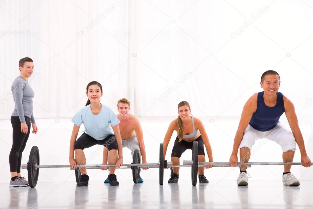 Multiethnic group with weightlifting bar workout in fitness cent Stock ...