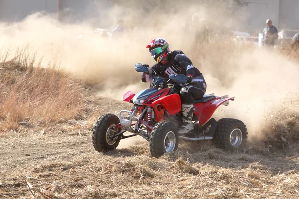 Quad Bike kicking up trail of dust on sand track during rally ra ...
