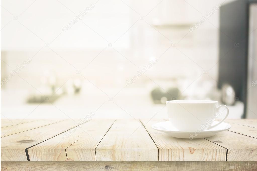 White cup on wooden table over blured kitchen interior background Stock ...