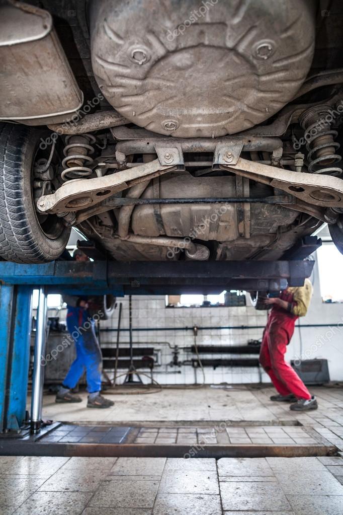 Inside a garage - two mechanics working on a car Stock Photo by ...