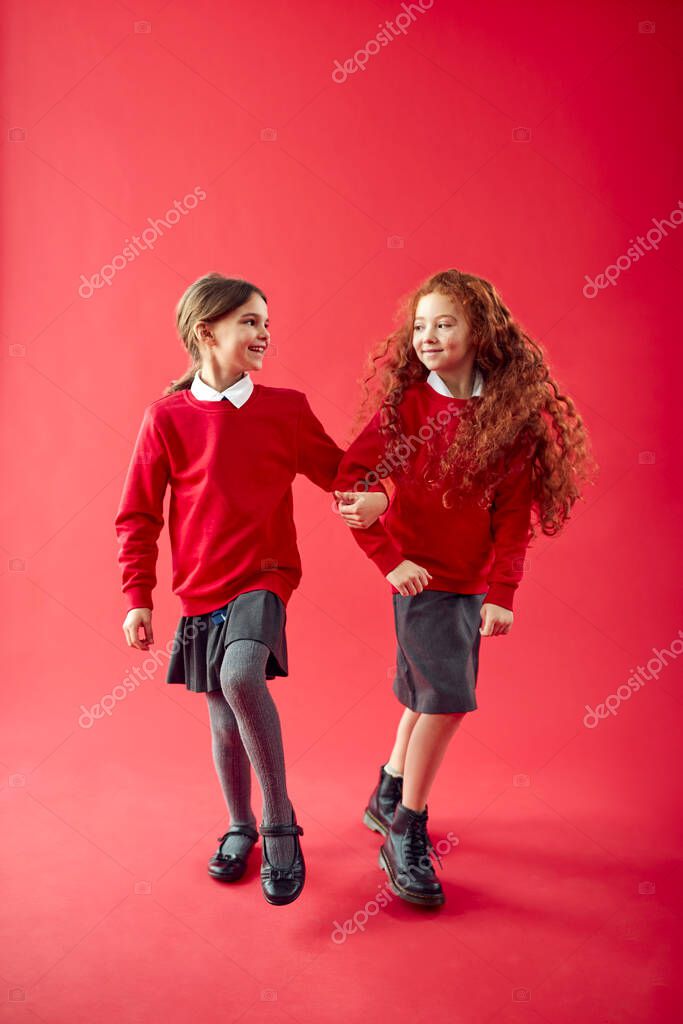 Dos alumnos de la escuela primaria que llevan uniformes que vinculan ...
