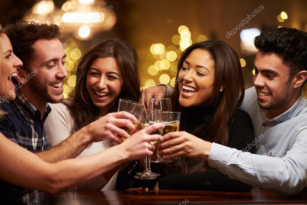 Grupo de amigos disfrutando de las bebidas en el bar — Foto de stock ...