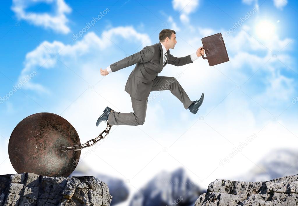 Businessman hopping over bottomless pit Stock Photo by ©cherezoff 92384036