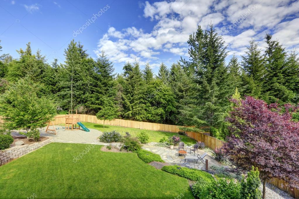 Large fenced backyard with patio and play set. — Stock Photo ...