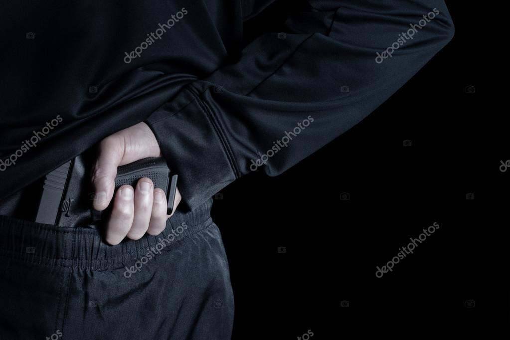 Back view of pistol being pull out of pants by male hand Stock Photo by ...