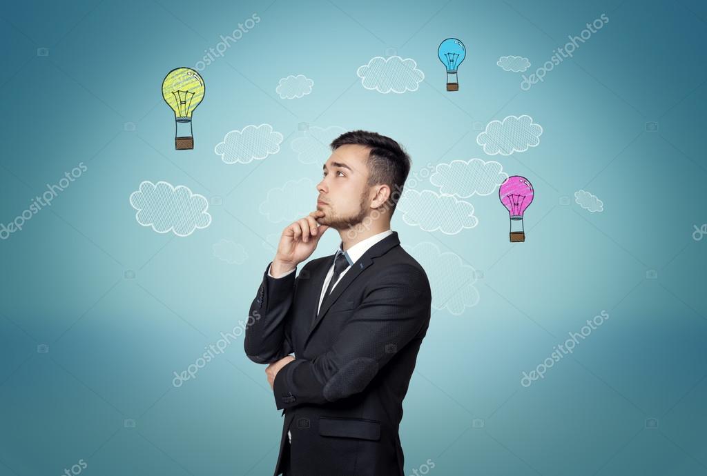 Thoughtful man on blue background with hand-drawn bulb-parachutes and ...