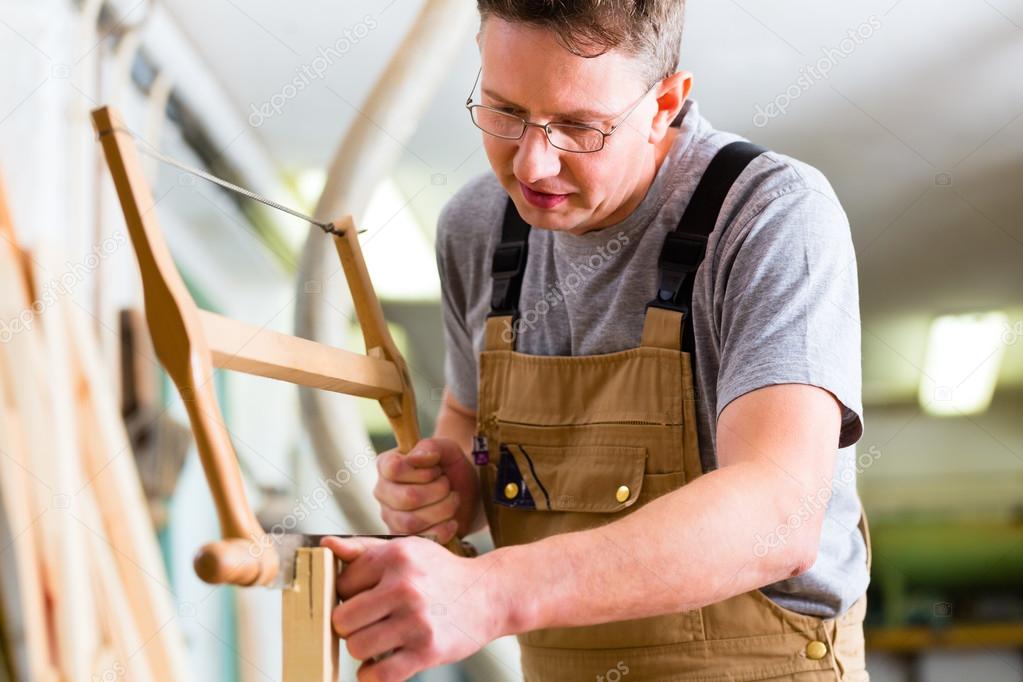Carpenter using hand saw Stock Photo by ©Kzenon 79209488