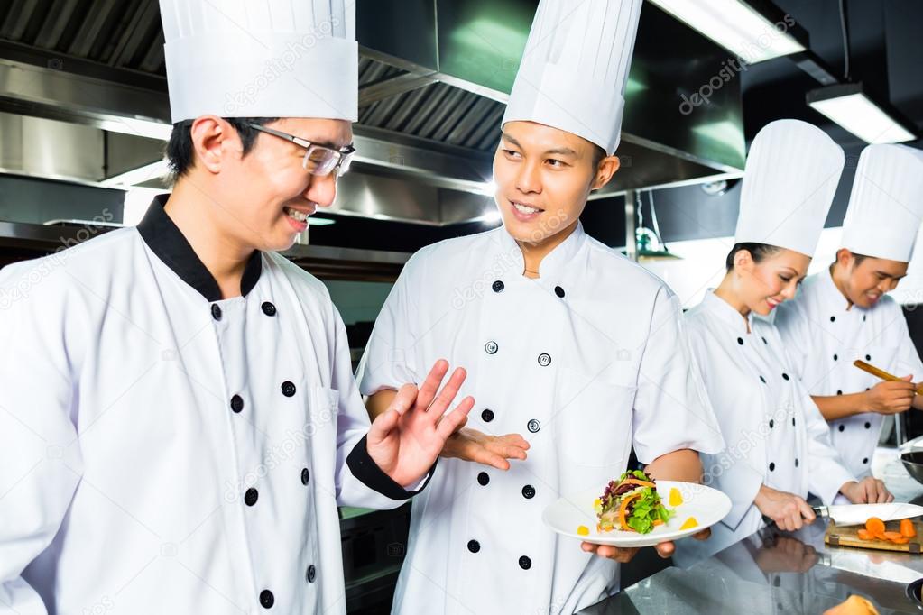 Asian Chef in restaurant kitchen cooking — Stock Photo © Kzenon #79329224