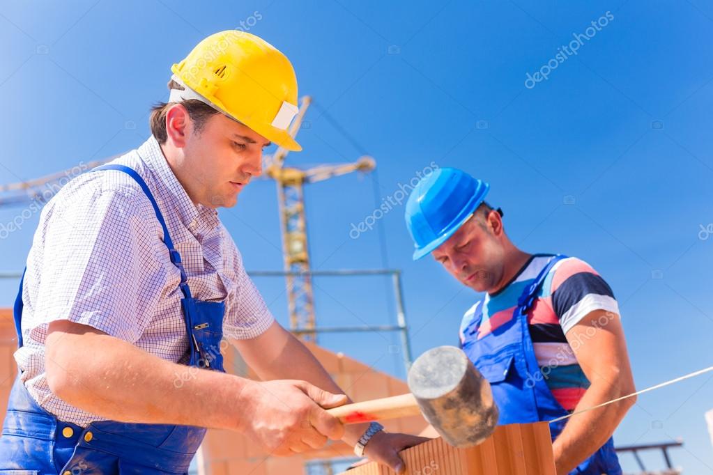 Construction site workers building walls on house Stock Photo by ...