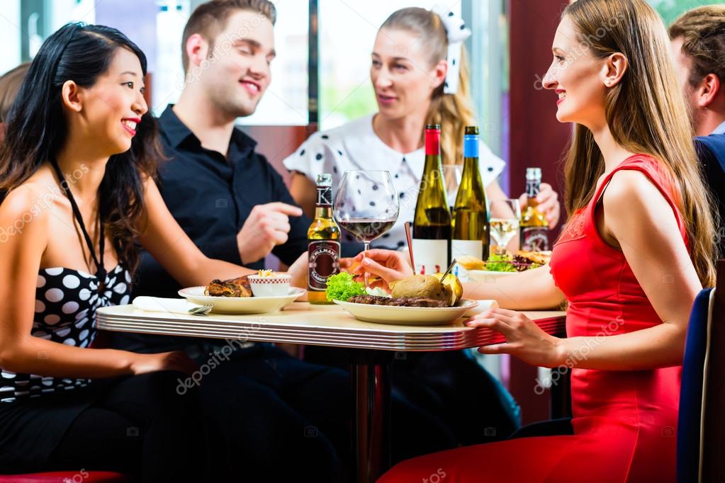 Amigos comiendo y bebiendo en el restaurante de comida rápida 2023
