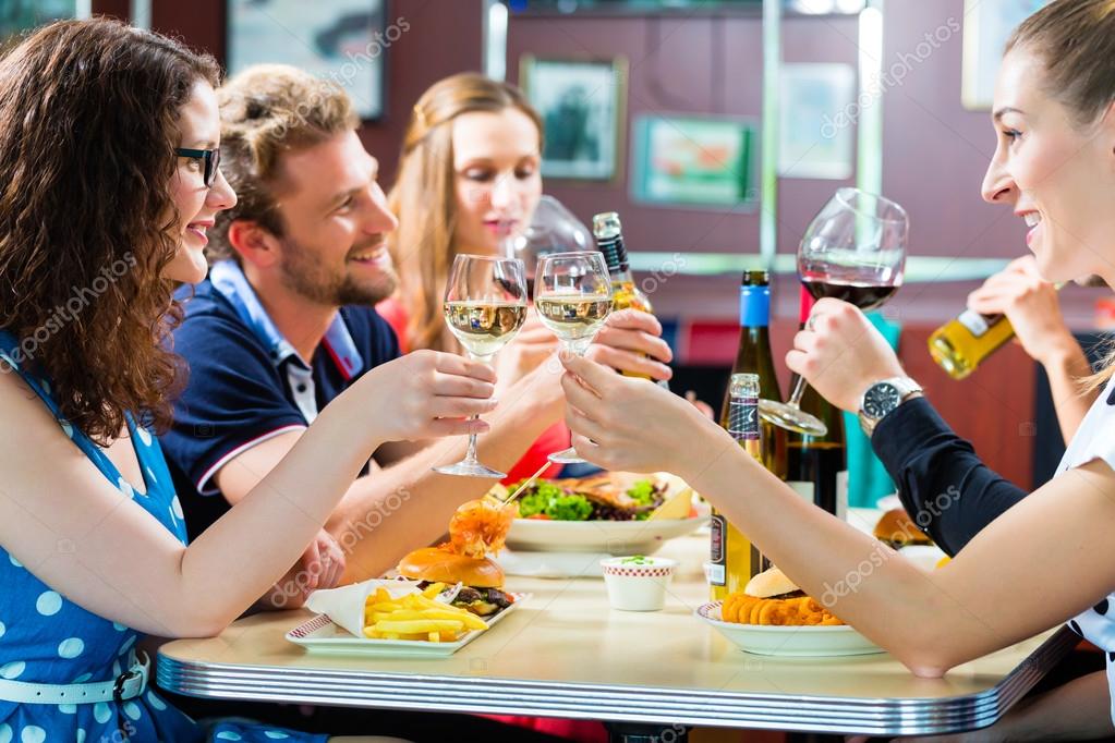 Amigos comiendo y bebiendo en el restaurante de comida rápida 2023
