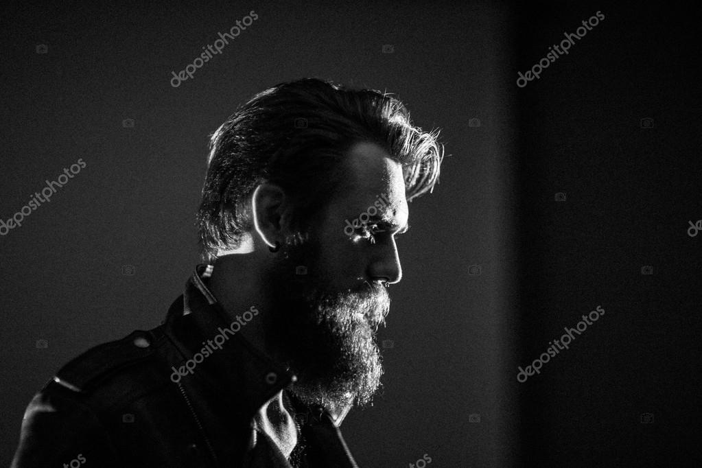 Brutal angry biker on a dark background. Stock Photo by ...
