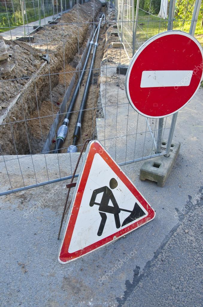 New heating system pipes and road signs on street Stock Photo by ...