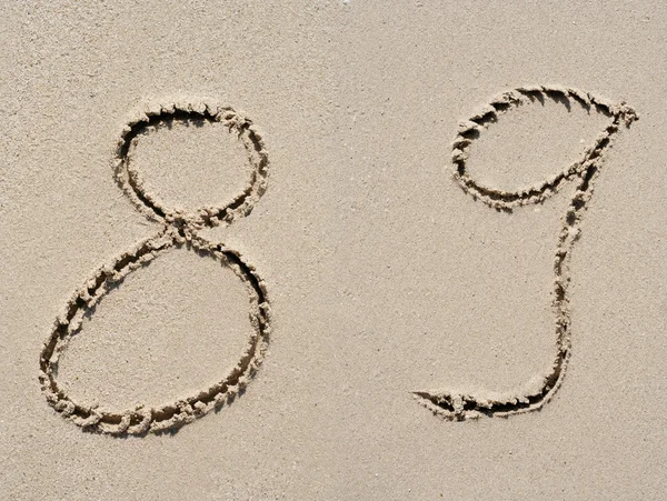Concept or conceptual sand font or number carved on exotic beach near ...